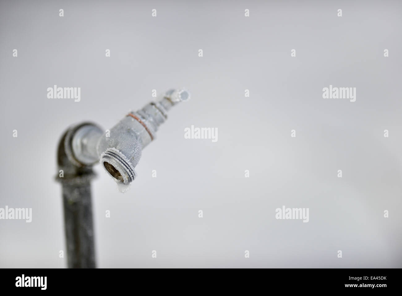 A frozen water faucet covered with ice crystals outdoors in the winter ...