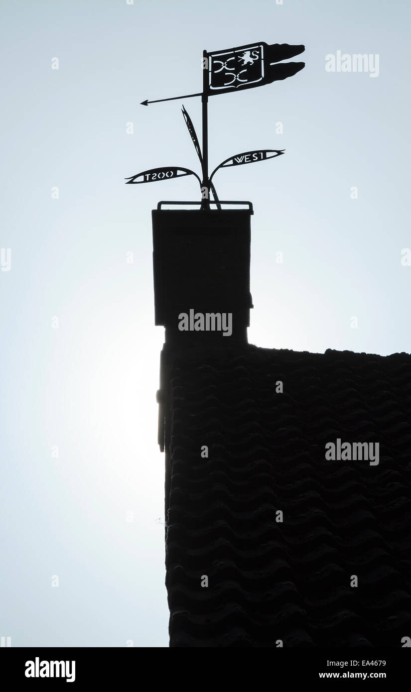 Silhouetted weather vane on a chimney stack pointing east Stock Photo ...