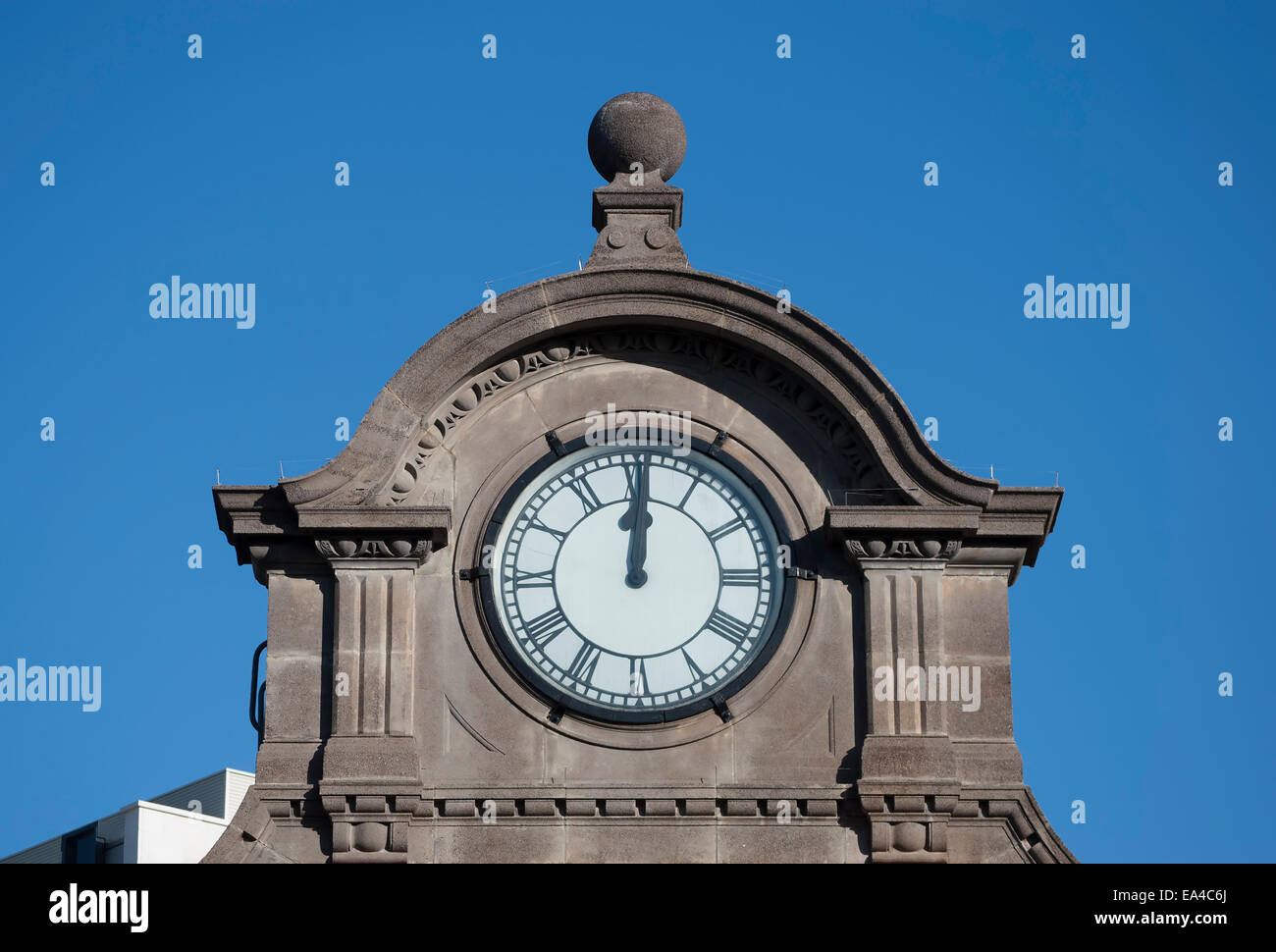 exterior clock face with roman numerals and hands at 12 o'clock ...