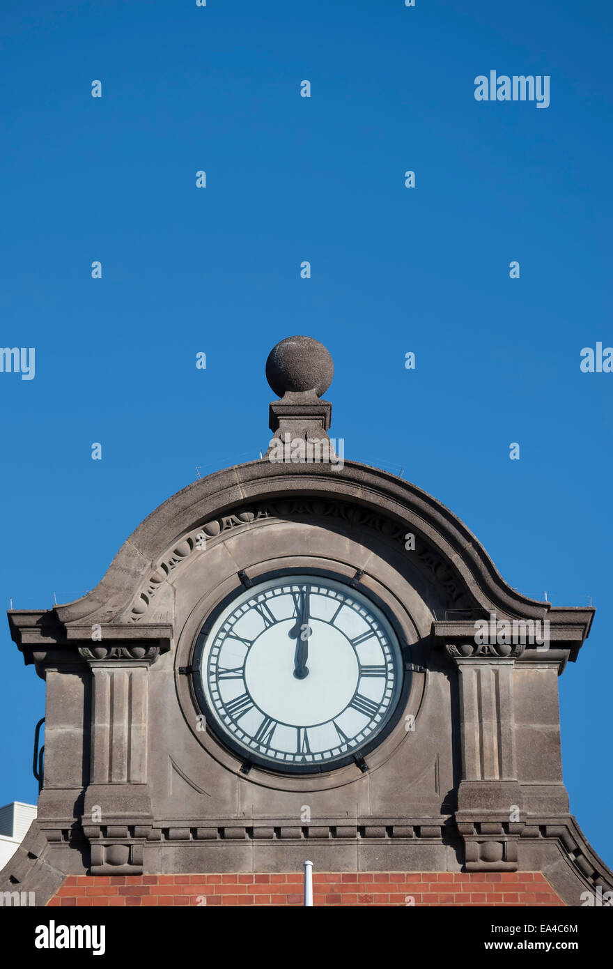 exterior clock face with roman numerals and hands at 12 o'clock ...