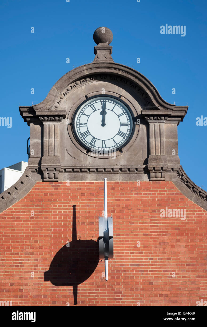 exterior clock face with roman numerals and hands at 12 o'clock ...