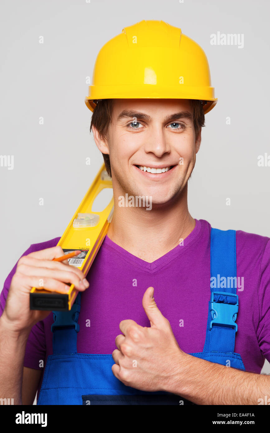 Repairman in helmet showing thumb up Stock Photo - Alamy
