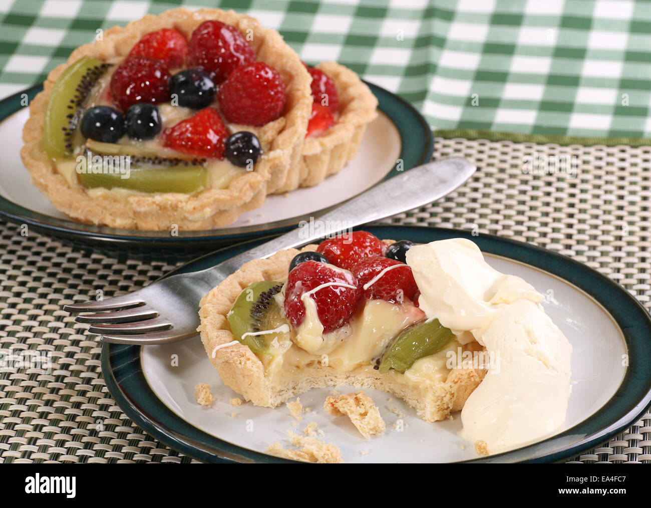 mixed fruit tartlet on a white plate with fresh dairy cream Stock Photo ...