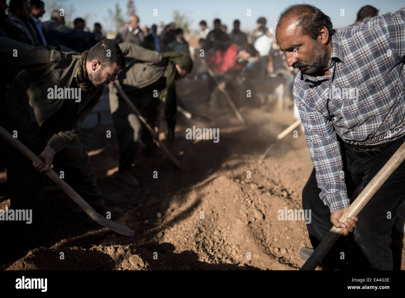 Suruc, Turkey. 06th Nov, 2014. Mourners cover with soil the grave of a ...