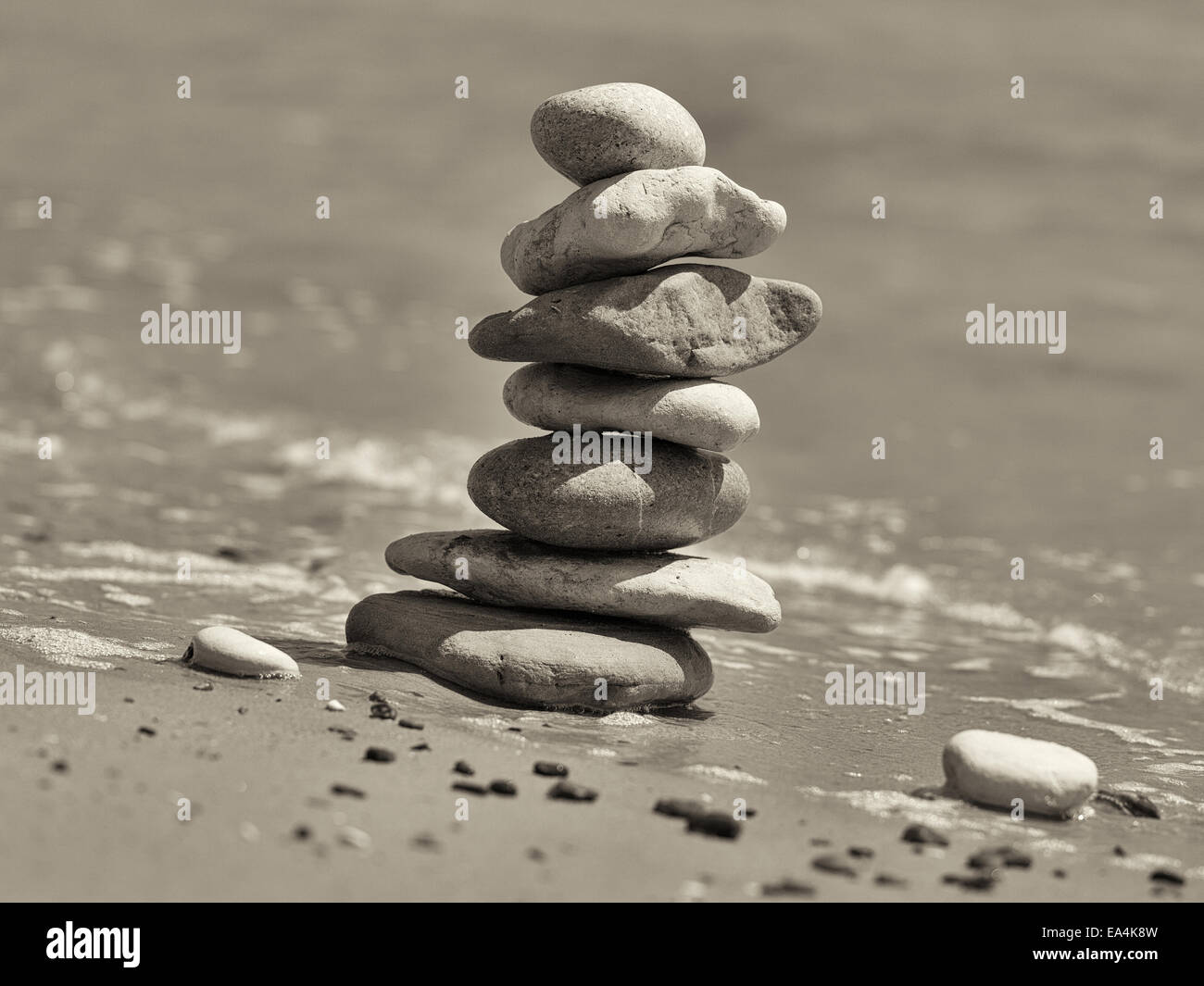 A black and white image of a tower made of flat stones standing on a ...