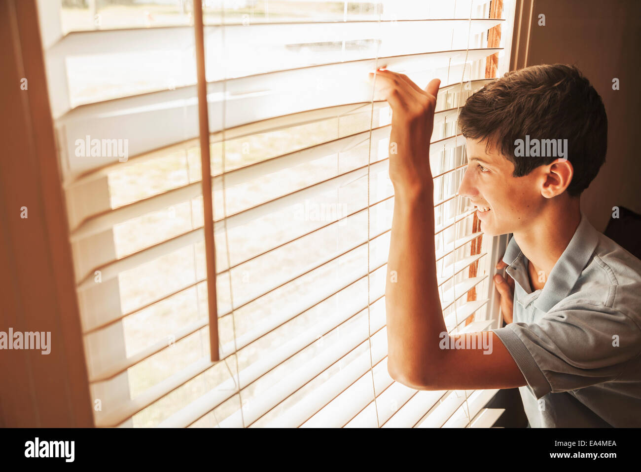 Teen boy looking out his window; Connecticut, United States of America ...