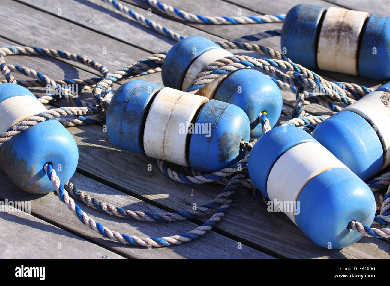 Nautical scene with blue buoys on a rope Stock Photo - Alamy