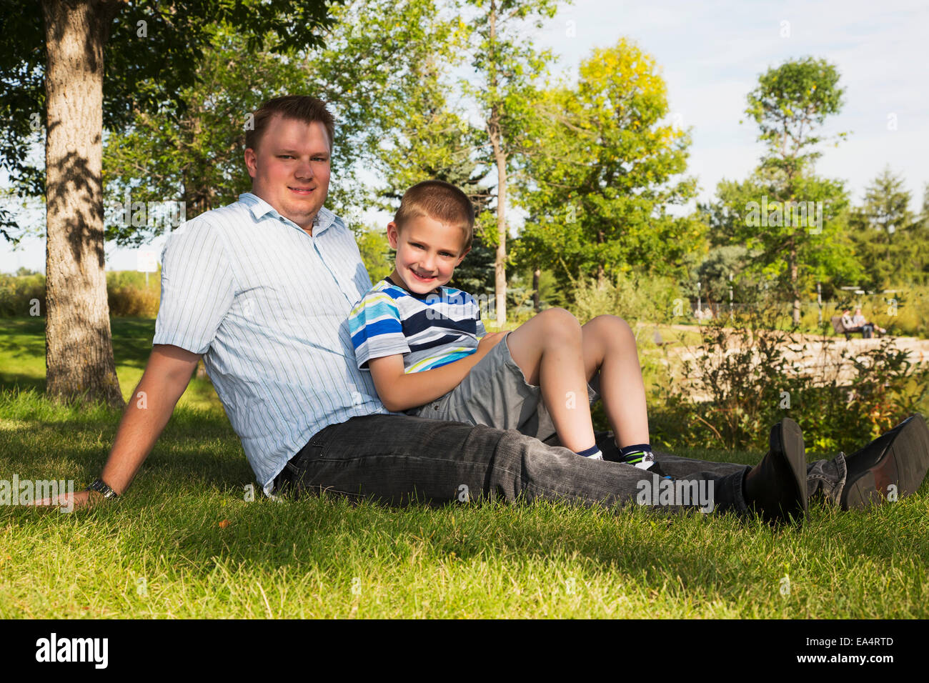 Portrait of a father and son hanging out in a park; Edmonton, Alberta ...