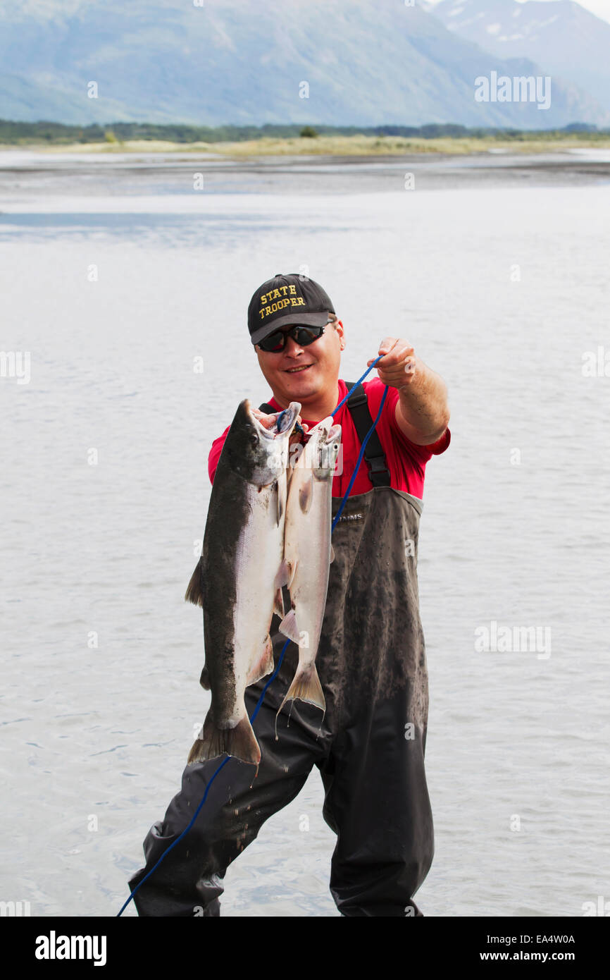 An Alaska native man shows off his Silver Salmon freshly caught in Jim ...