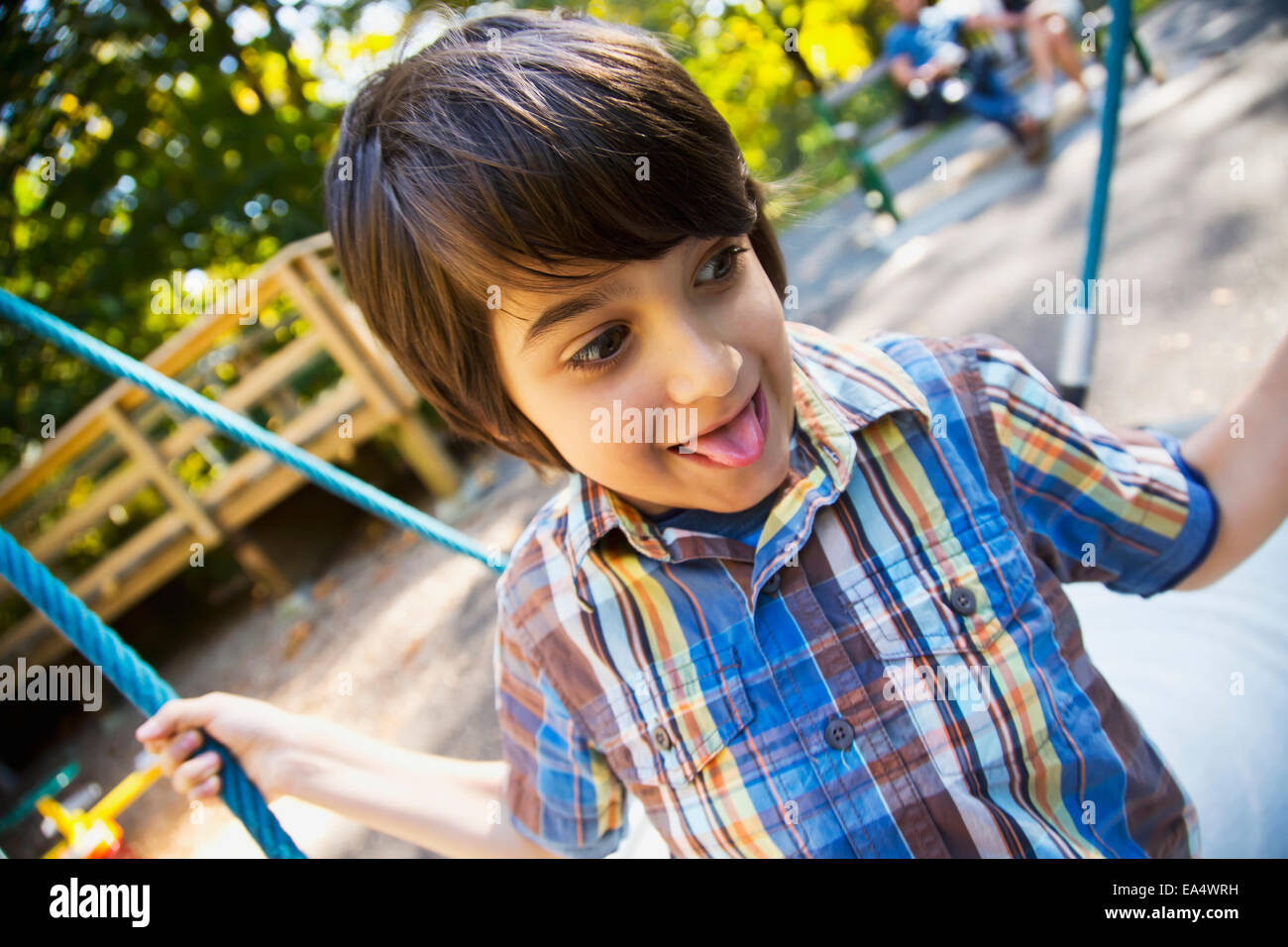 Young boy playing on dish swing at a playground in a park in autumn ...