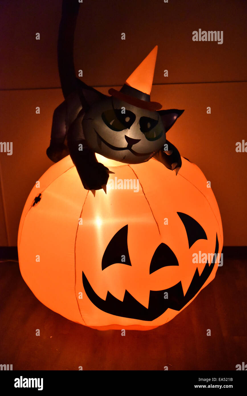 An inflatable halloween pumpkin with a black cat Stock Photo - Alamy