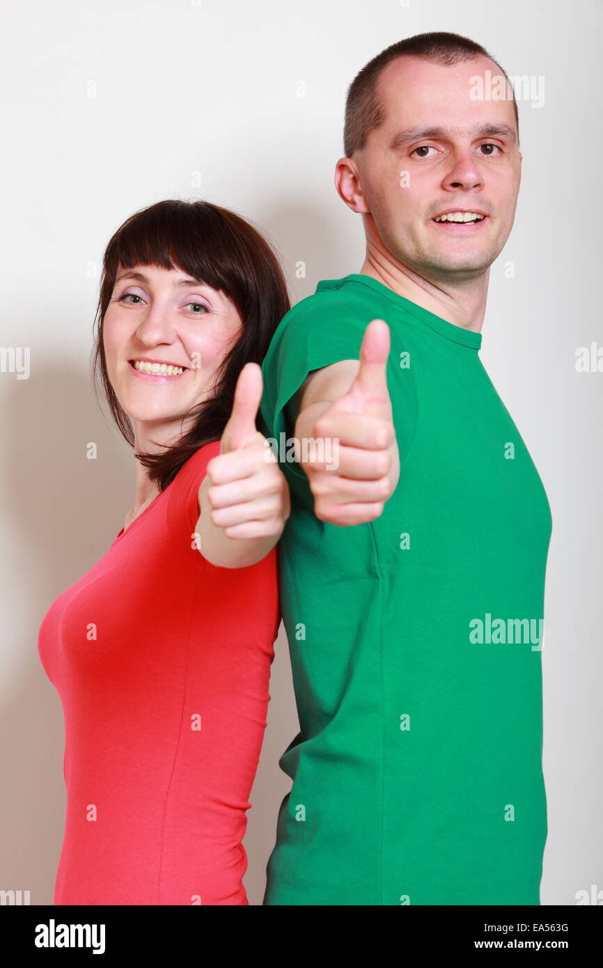 Smiling woman and man showing thumbs up, showing positive emotions ...