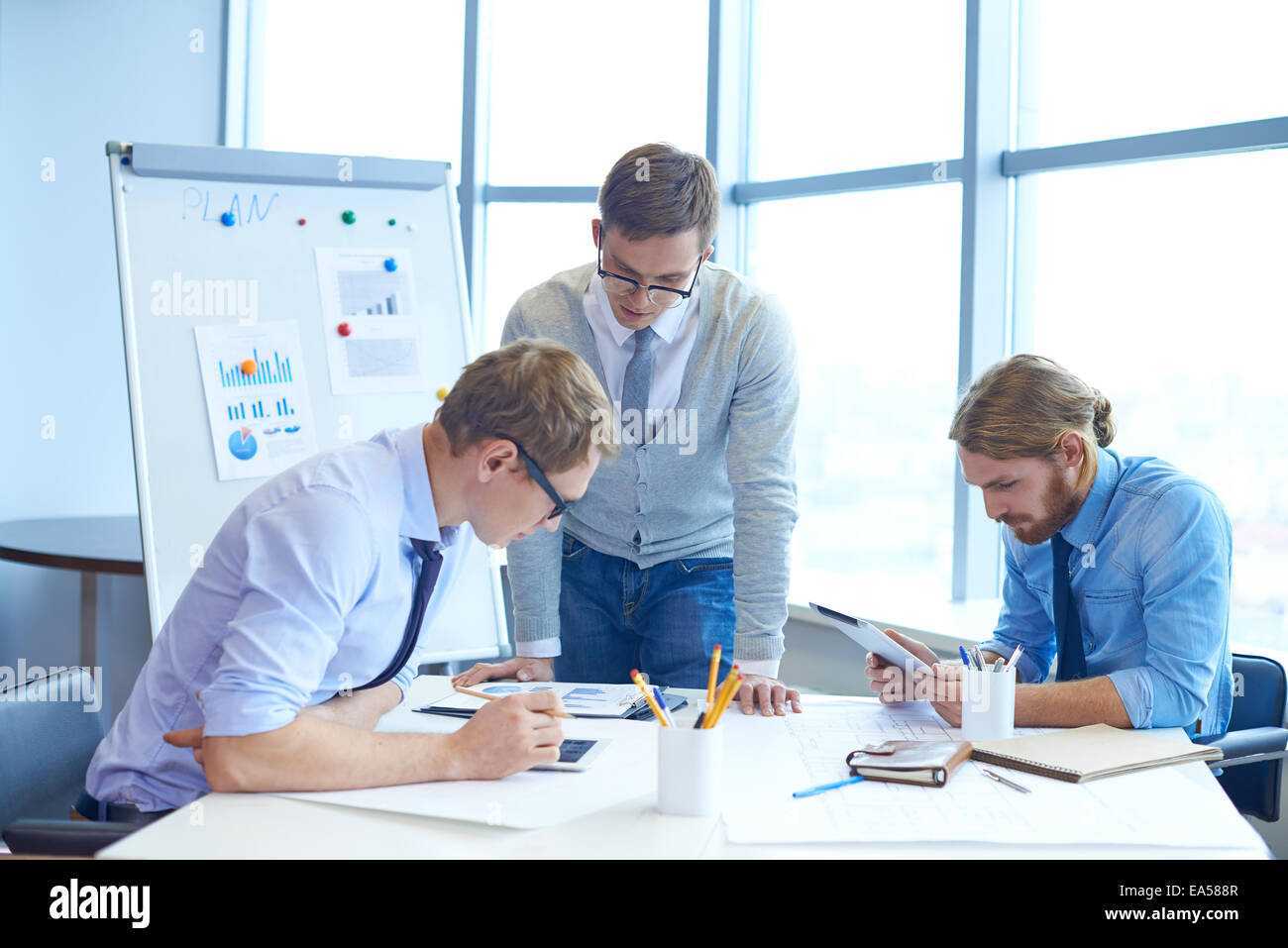 Group of serious businessmen working together at meeting Stock Photo ...