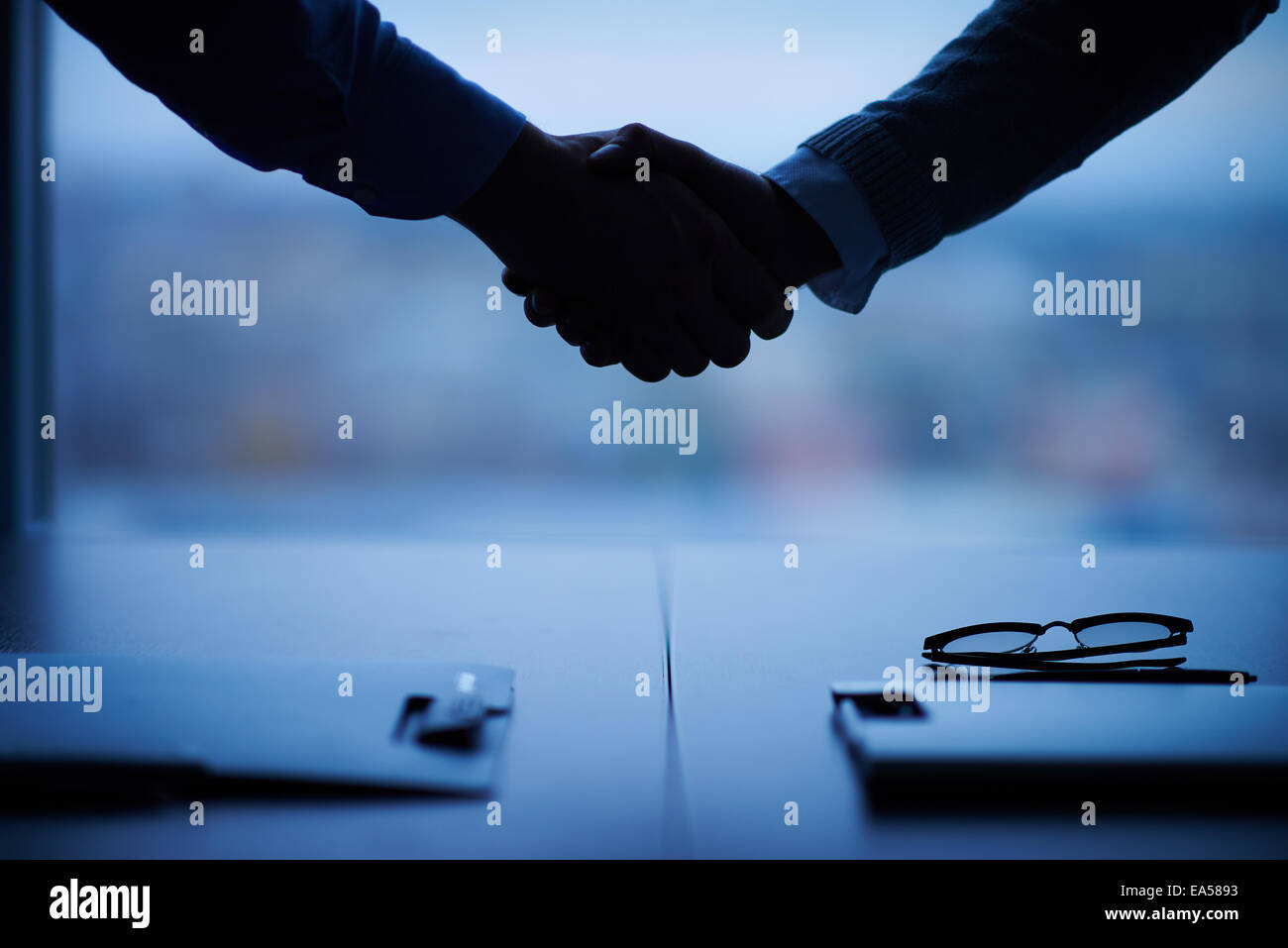 Outline of handshake of two businessmen over workplace Stock Photo - Alamy