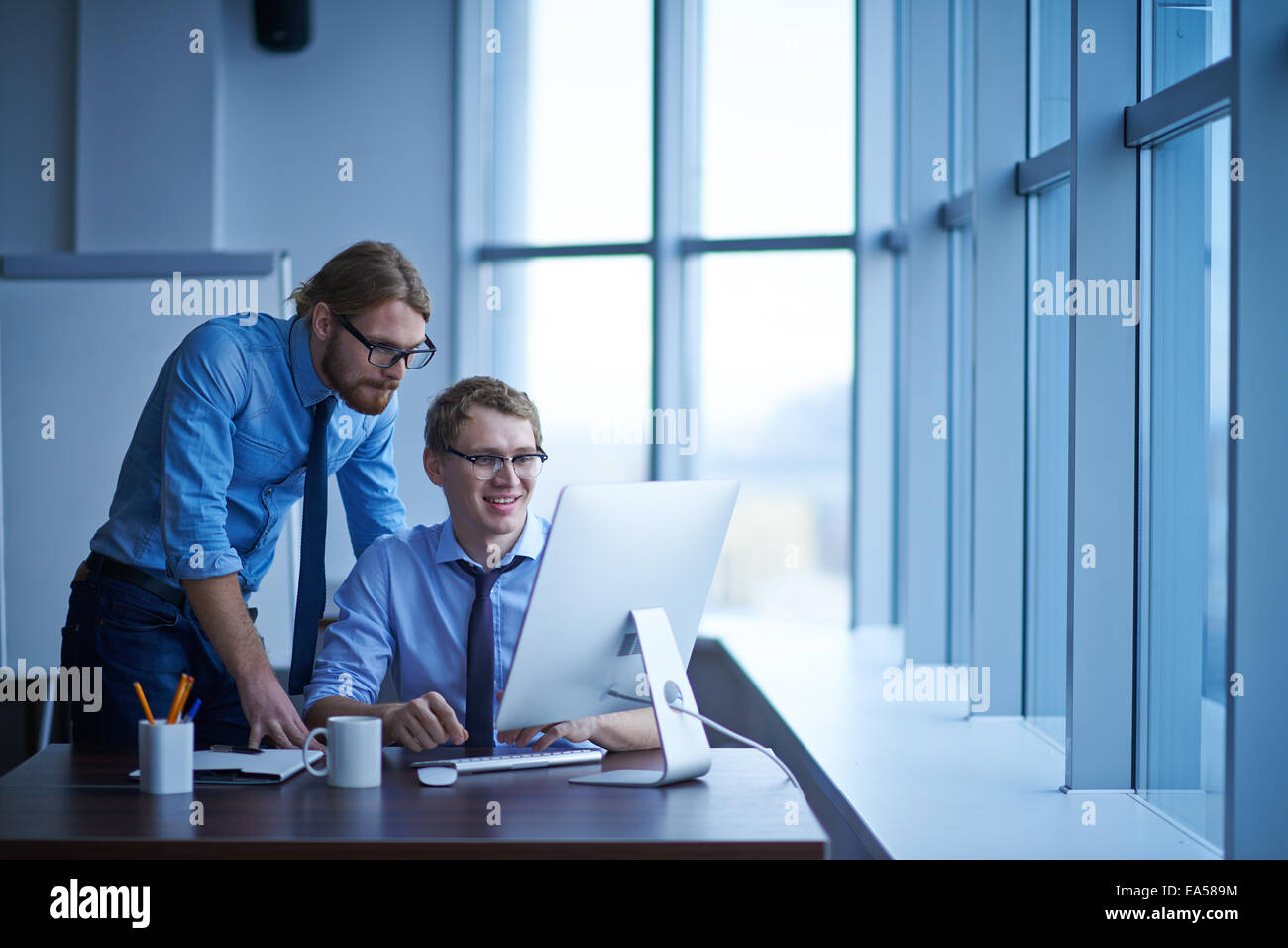 Two elegant businessmen networking on computer in office Stock Photo ...