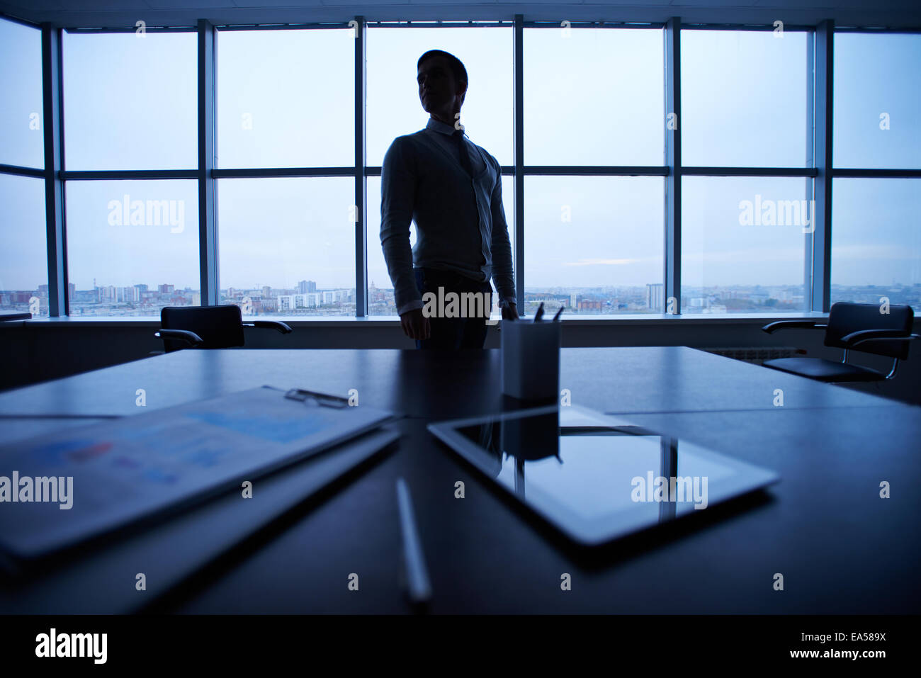 Business documents and touchpad at workplace on background of man by ...