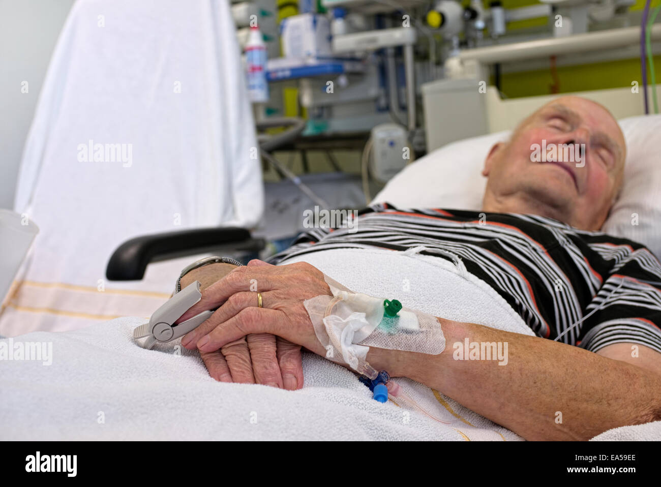 Senior man with cannulae and band-aid being in intensive care after ...