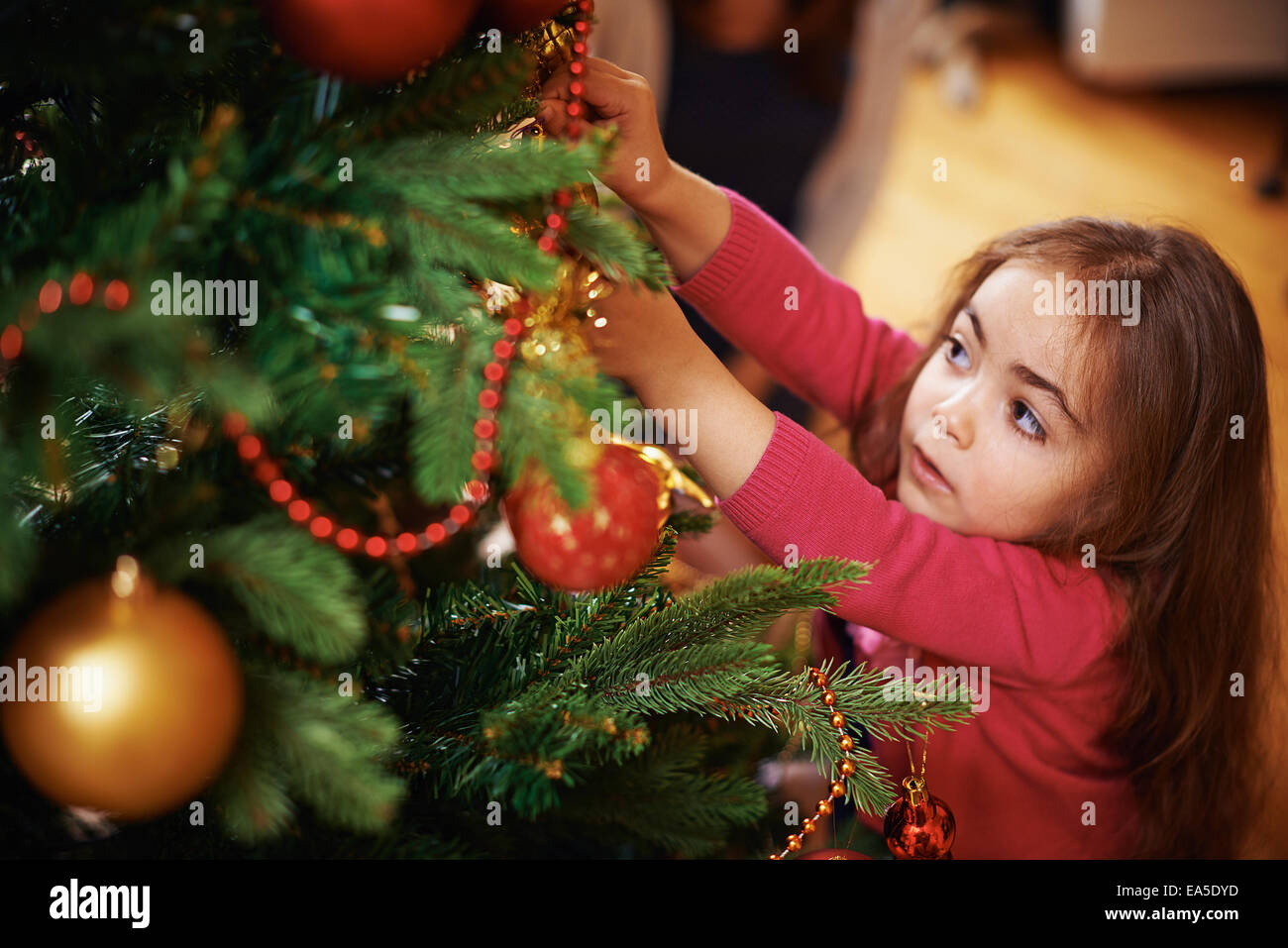 Cute little girl decorating Christmas tree Stock Photo - Alamy