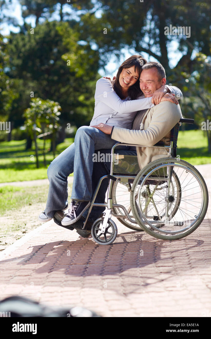 Woman hugging man in wheelchair Stock Photo - Alamy