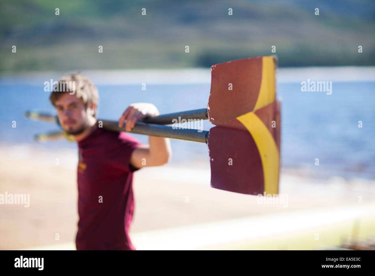 Rower holding oar at lakeshore Stock Photo - Alamy