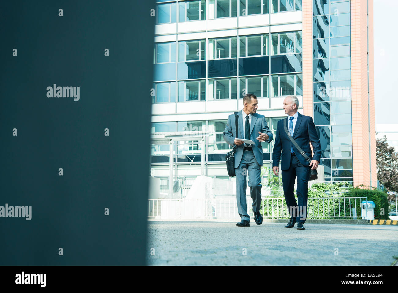 Two businessmen talking outside office building Stock Photo - Alamy