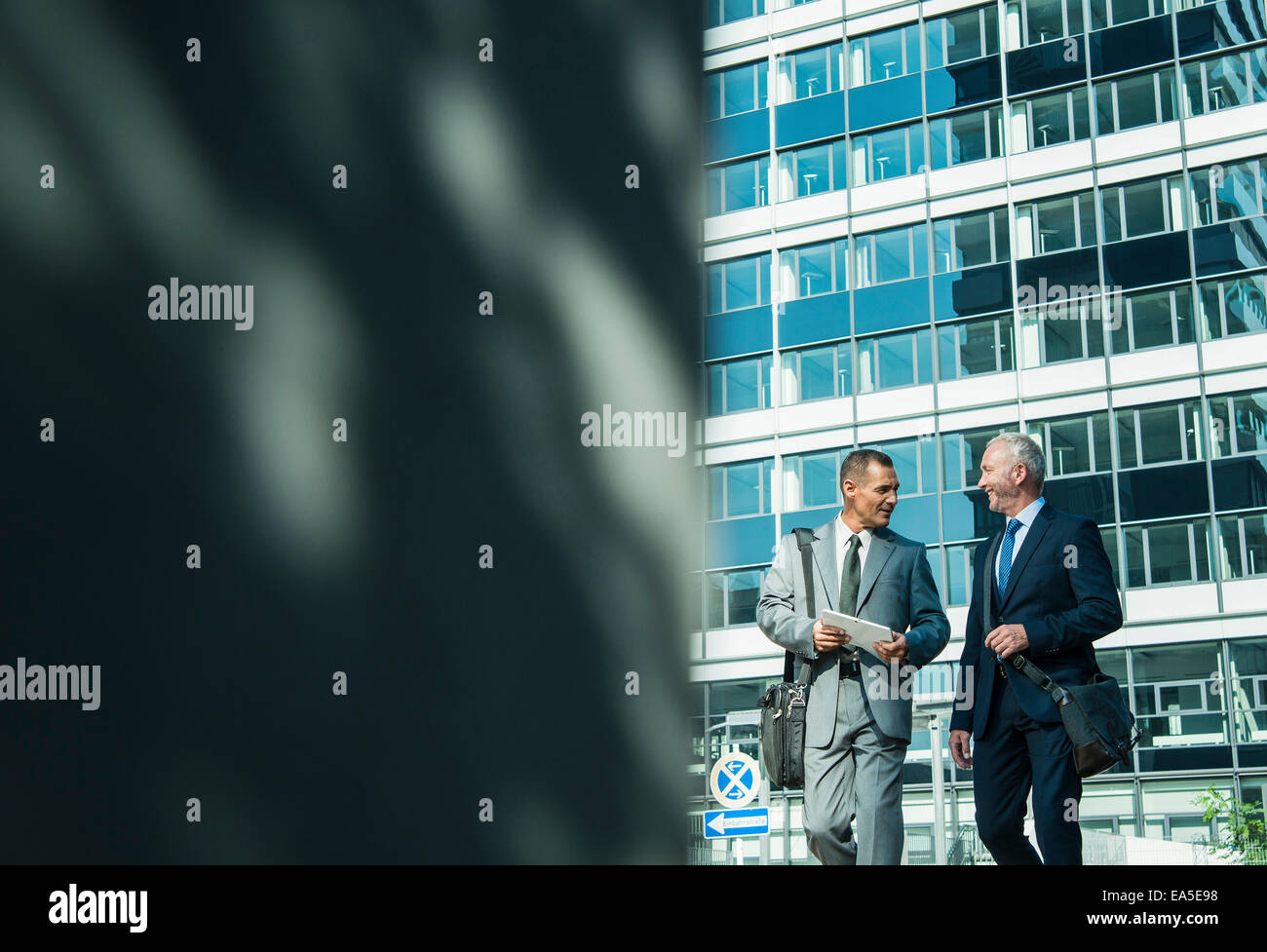 Two businessmen talking outside office building Stock Photo - Alamy