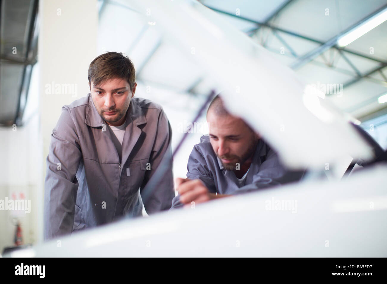Two car mechanics at work in repair garage Stock Photo - Alamy