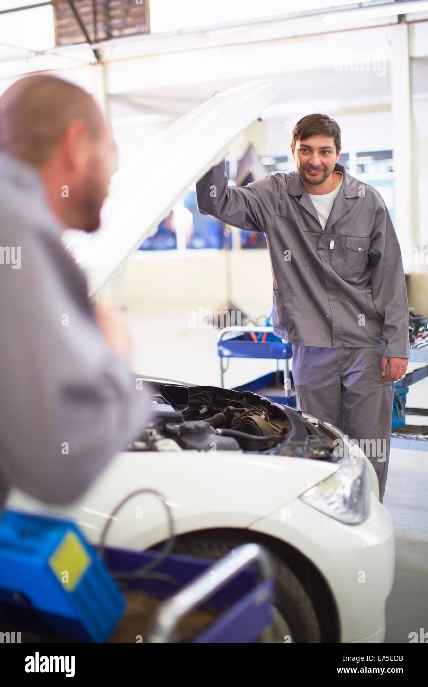 Two car mechanics at work in repair garage Stock Photo - Alamy