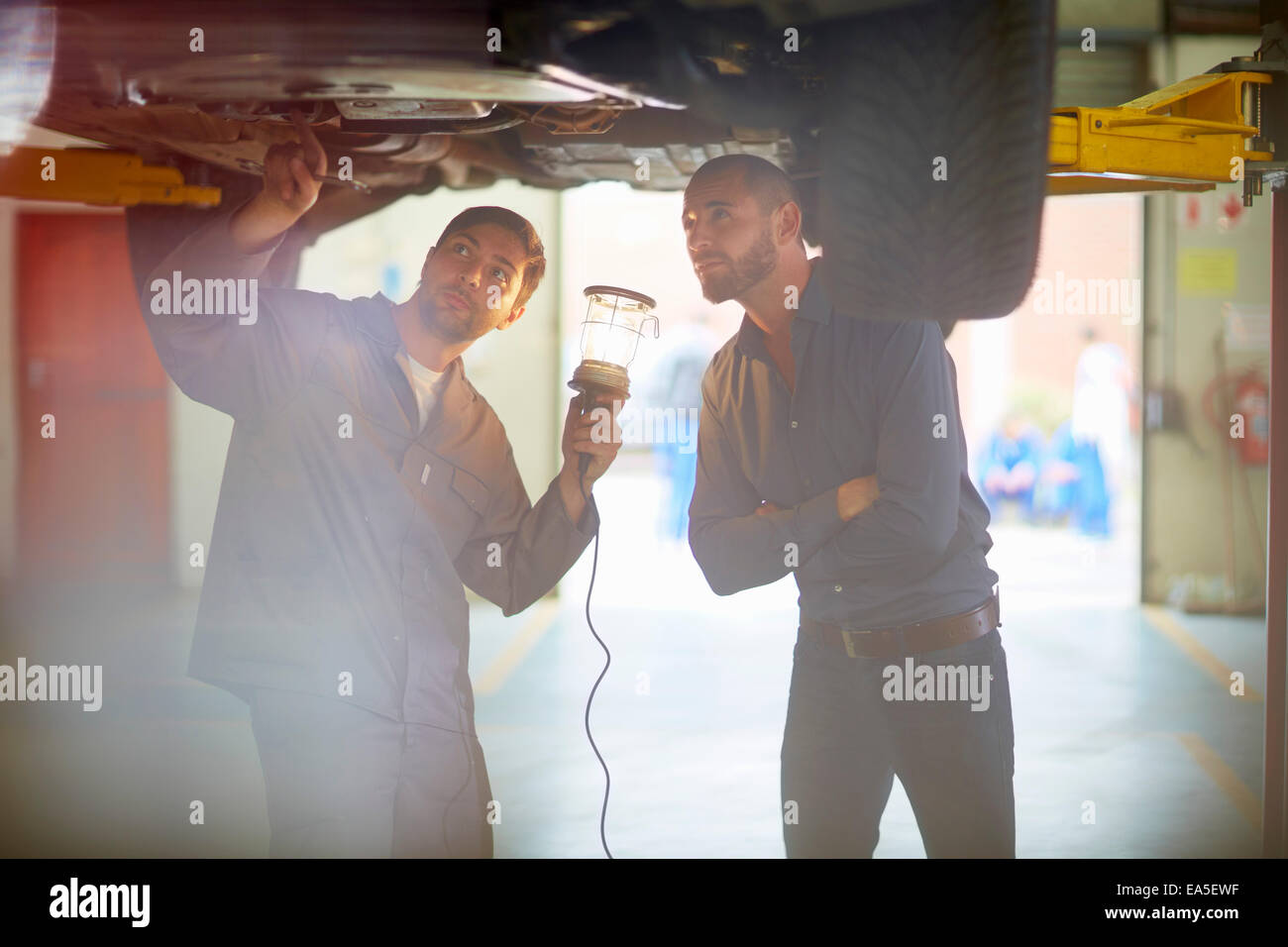 Car mechanic with client in repair garage Stock Photo - Alamy