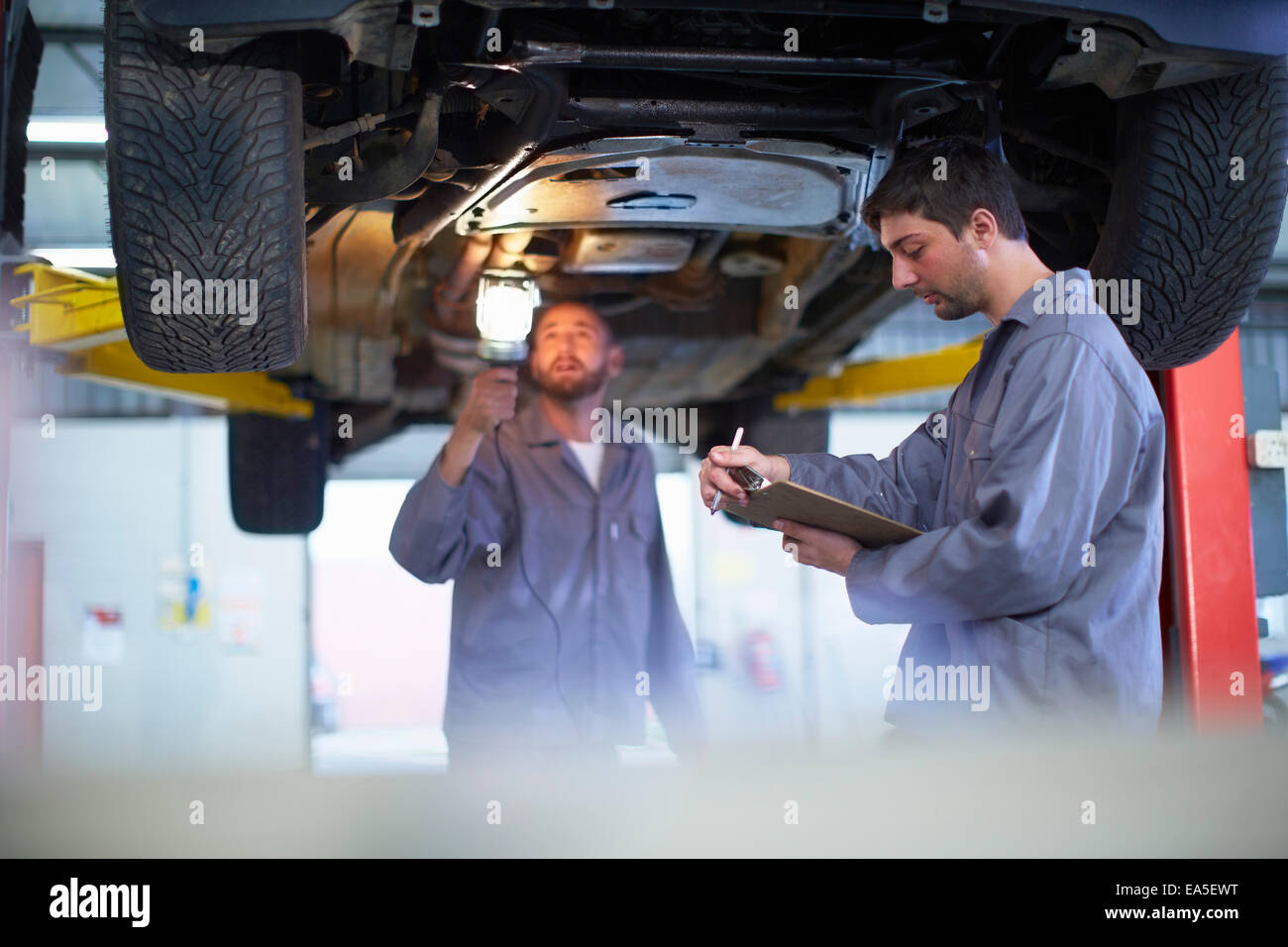 Two car mechanics at work in repair garage Stock Photo - Alamy