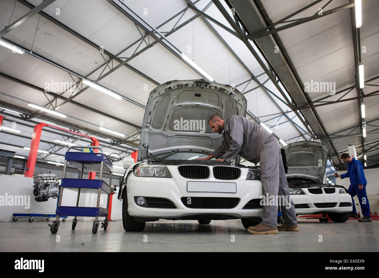 Two car mechanics at work in repair garage Stock Photo - Alamy