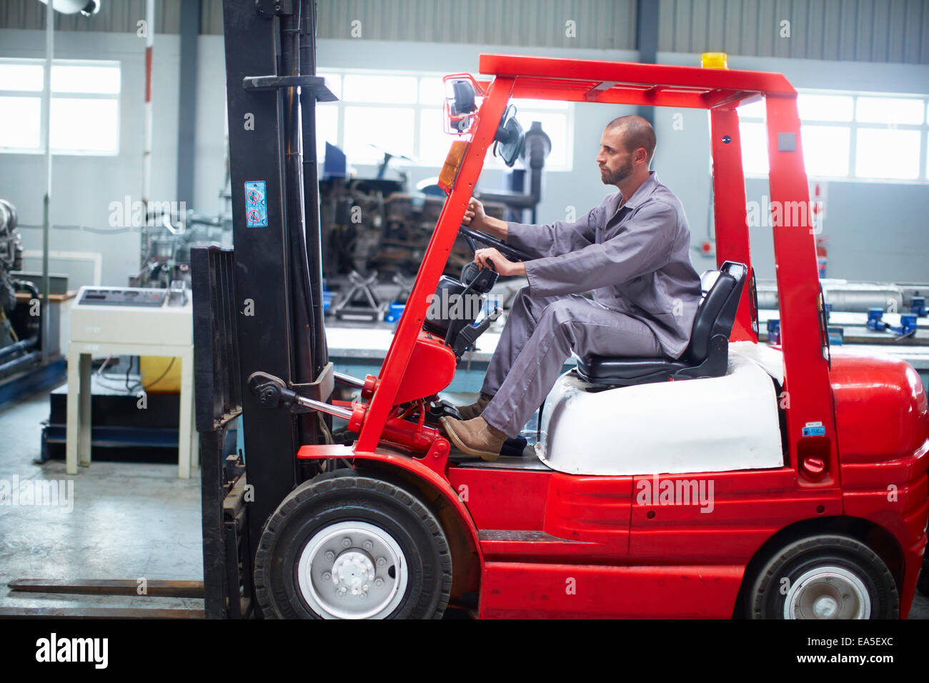 Worker on forklift in factory Stock Photo - Alamy