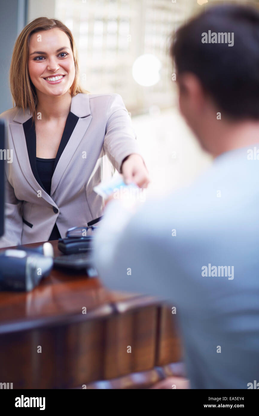 Man at counter paying with credit card Stock Photo - Alamy