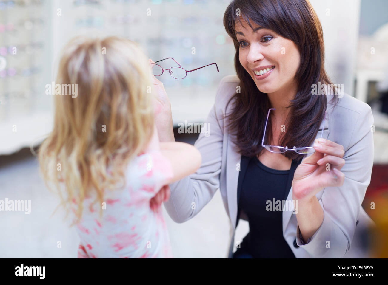 Girl at the optician trying on glasses Stock Photo - Alamy