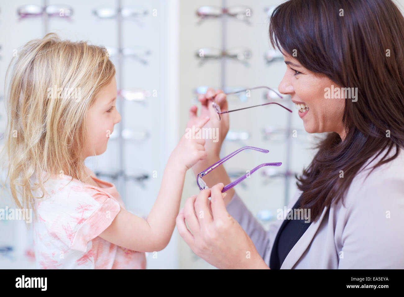Girl at the optician trying on glasses Stock Photo - Alamy