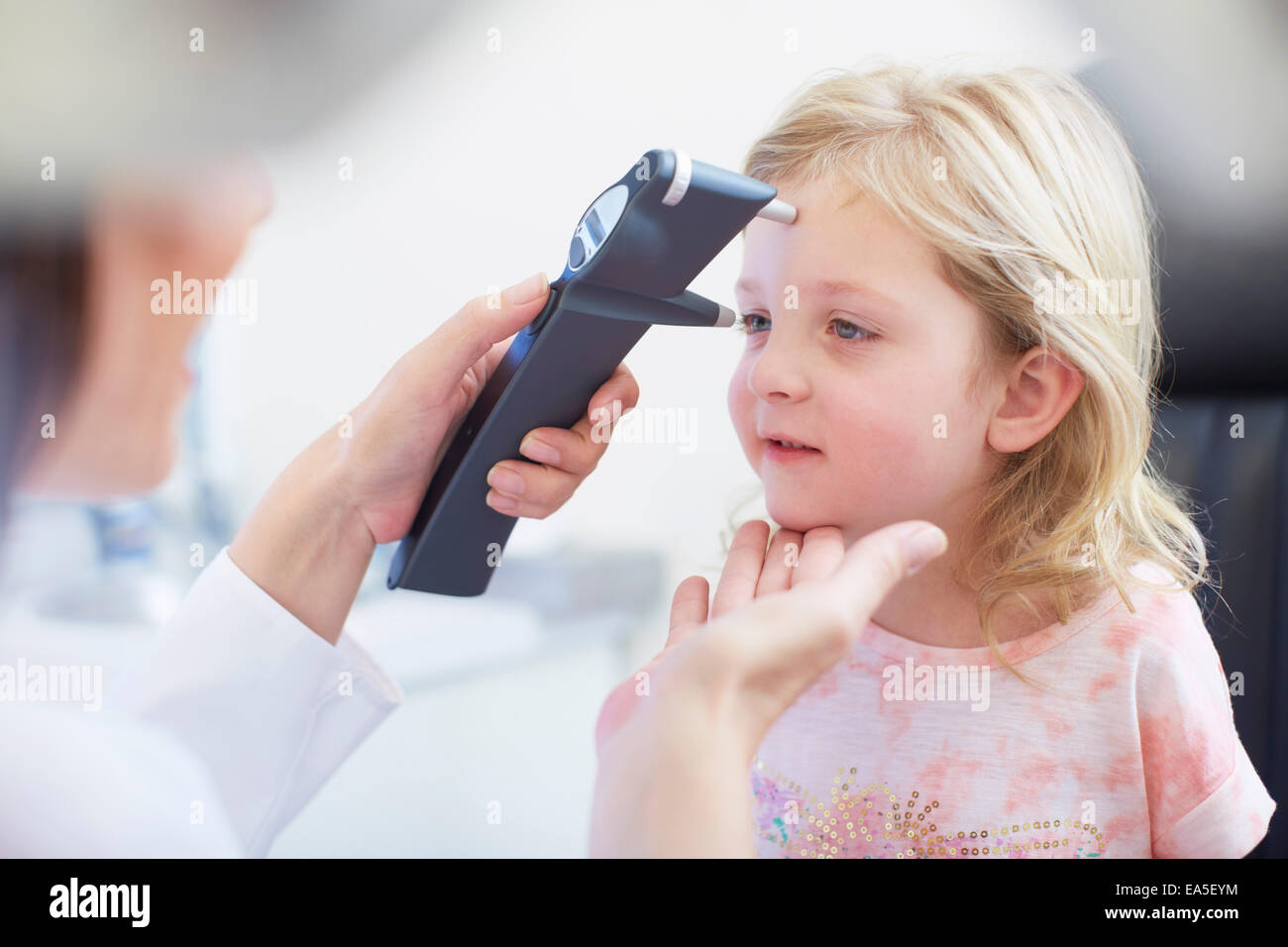 Eye doctor examining girl's vision Stock Photo - Alamy