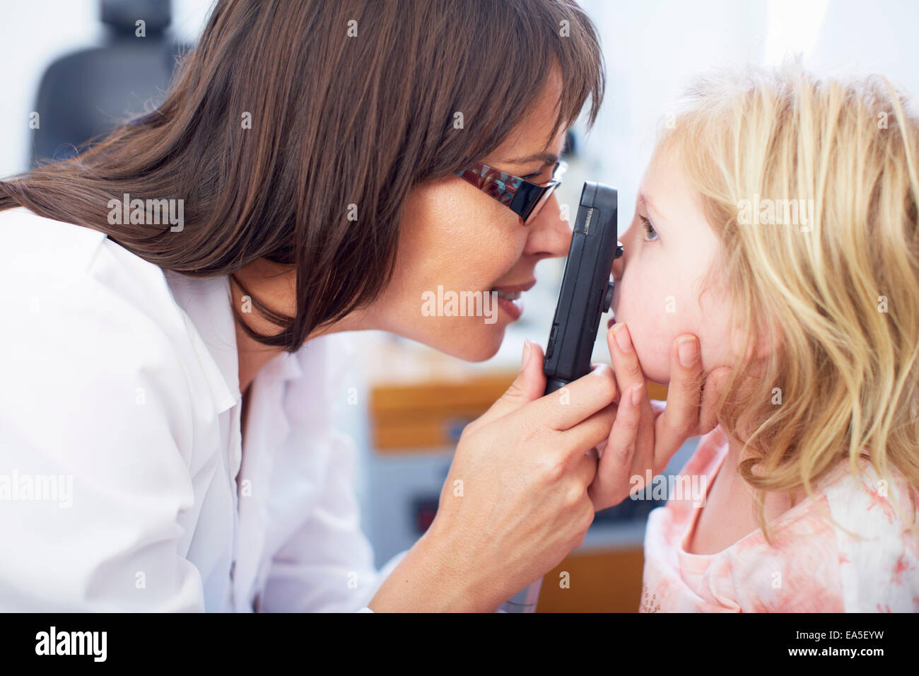 Eye doctor examining girl's vision Stock Photo - Alamy