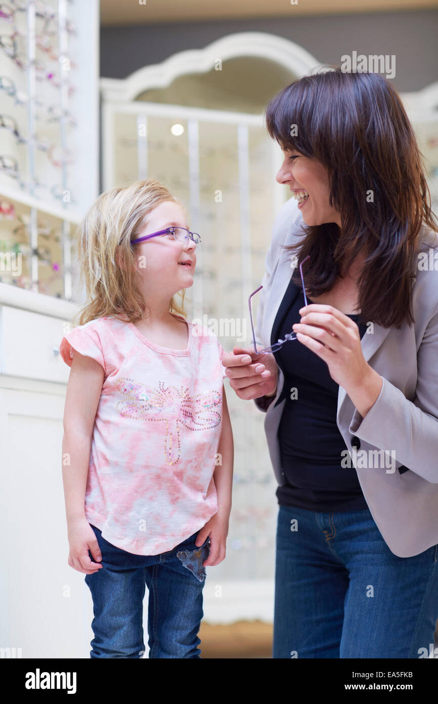 Girl at the optician trying on glasses Stock Photo - Alamy