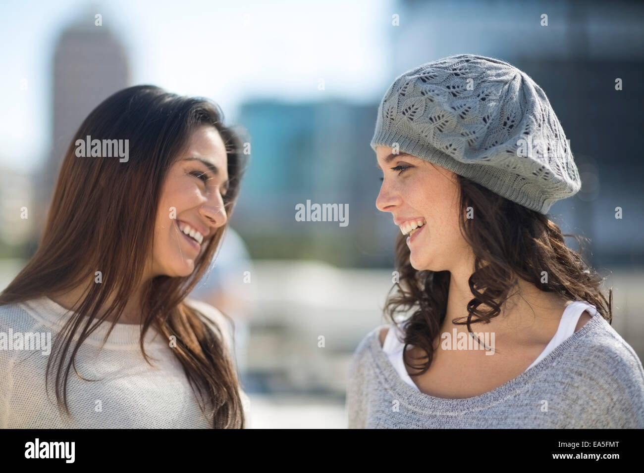 Two smiling female friends communicating Stock Photo - Alamy