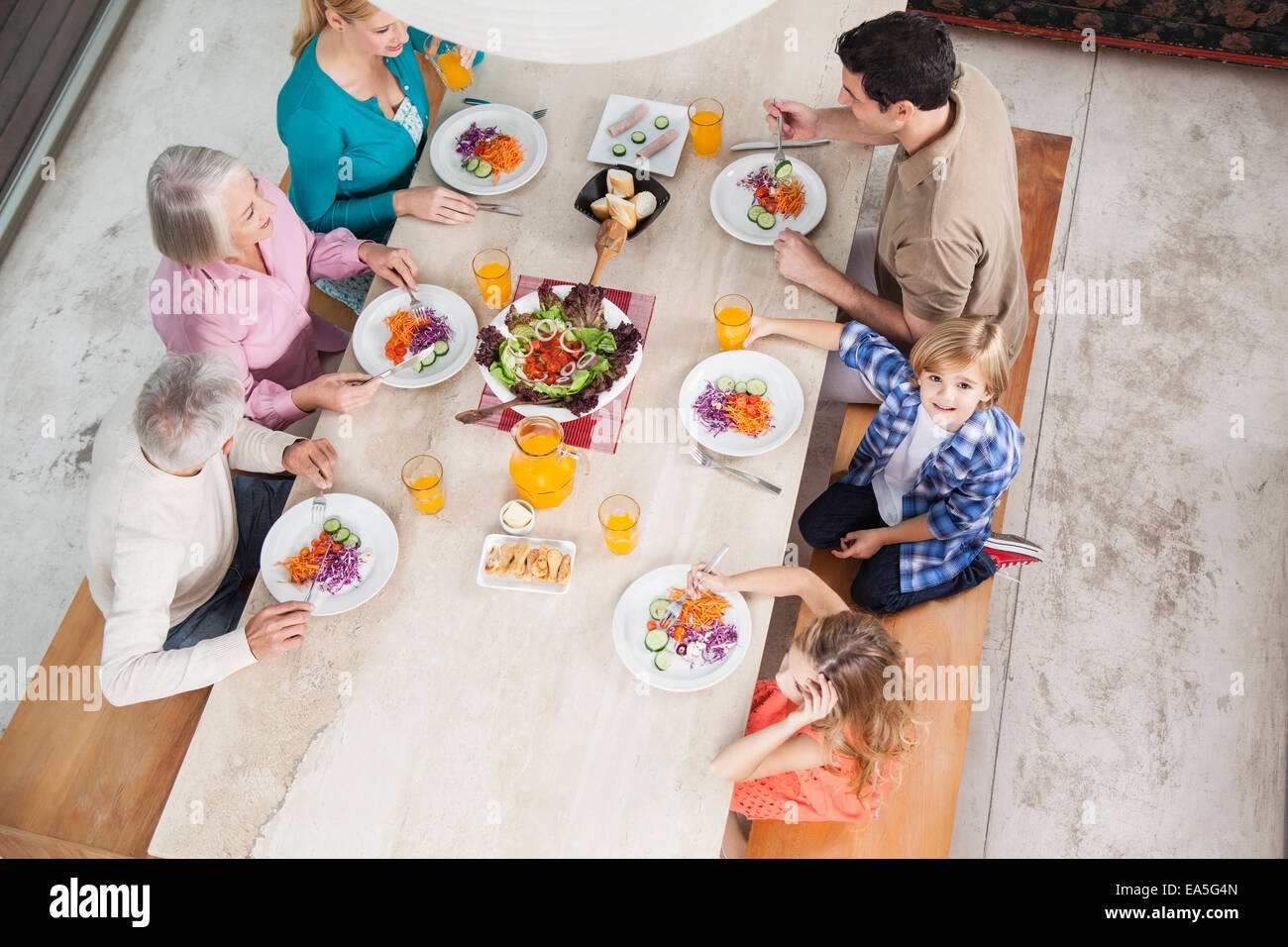 Extended family with salad and juice at dining table Stock Photo - Alamy