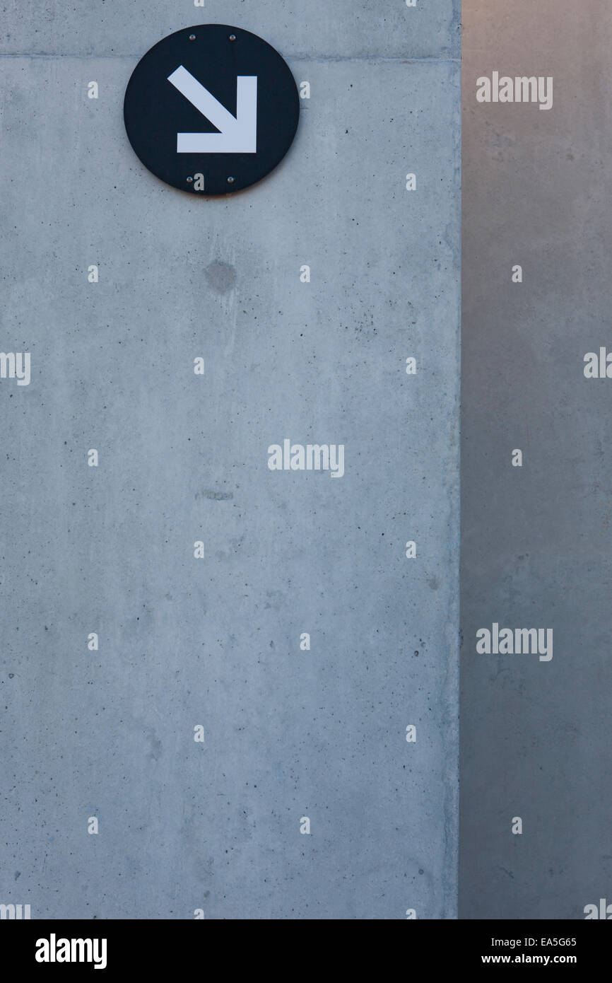 Arrow sign at concrete wall Stock Photo - Alamy