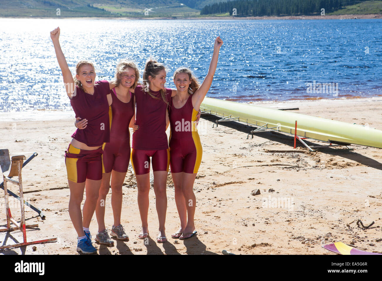Four female rowers cheering at lakeshore Stock Photo - Alamy
