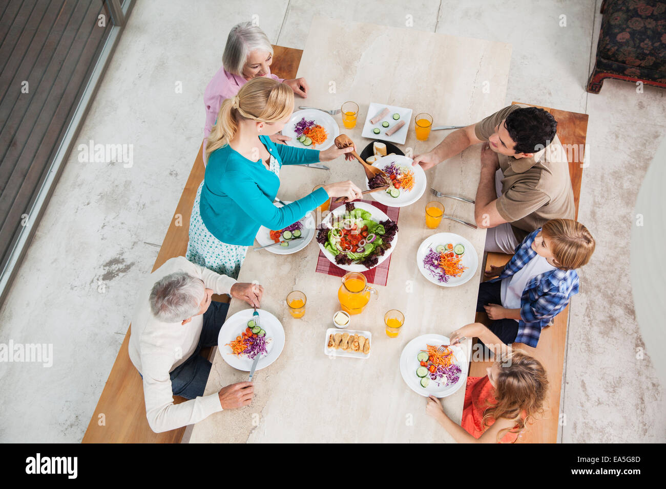 Extended family with salad and juice at dining table Stock Photo - Alamy