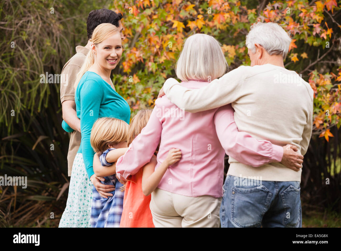 Extended family embracing in garden Stock Photo - Alamy