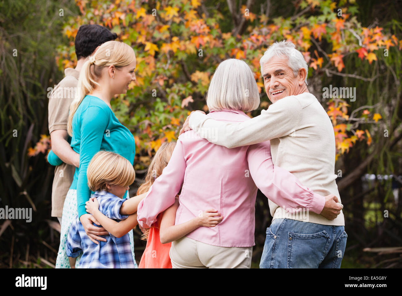 Extended family embracing in garden Stock Photo - Alamy