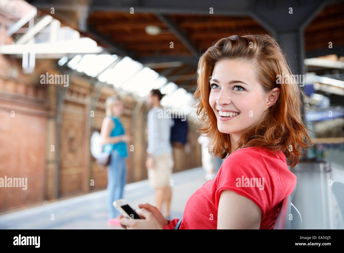 Germany, Berlin, Young woman using smart phone at train station Stock ...