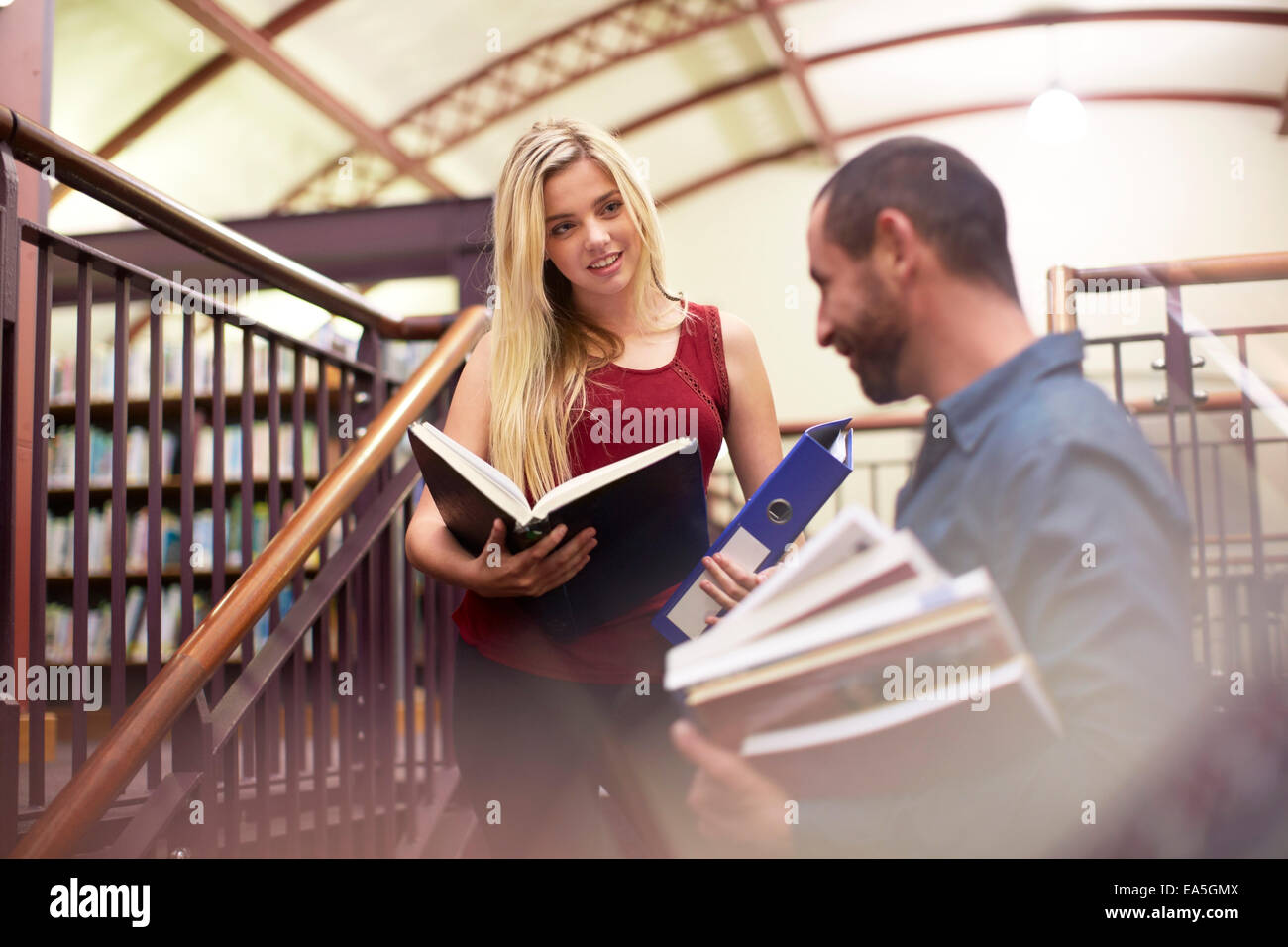 Two students on staircase in a library Stock Photo - Alamy