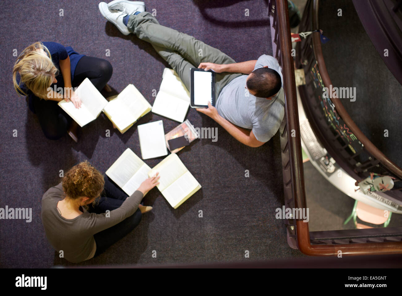 Three students learning in a library Stock Photo - Alamy