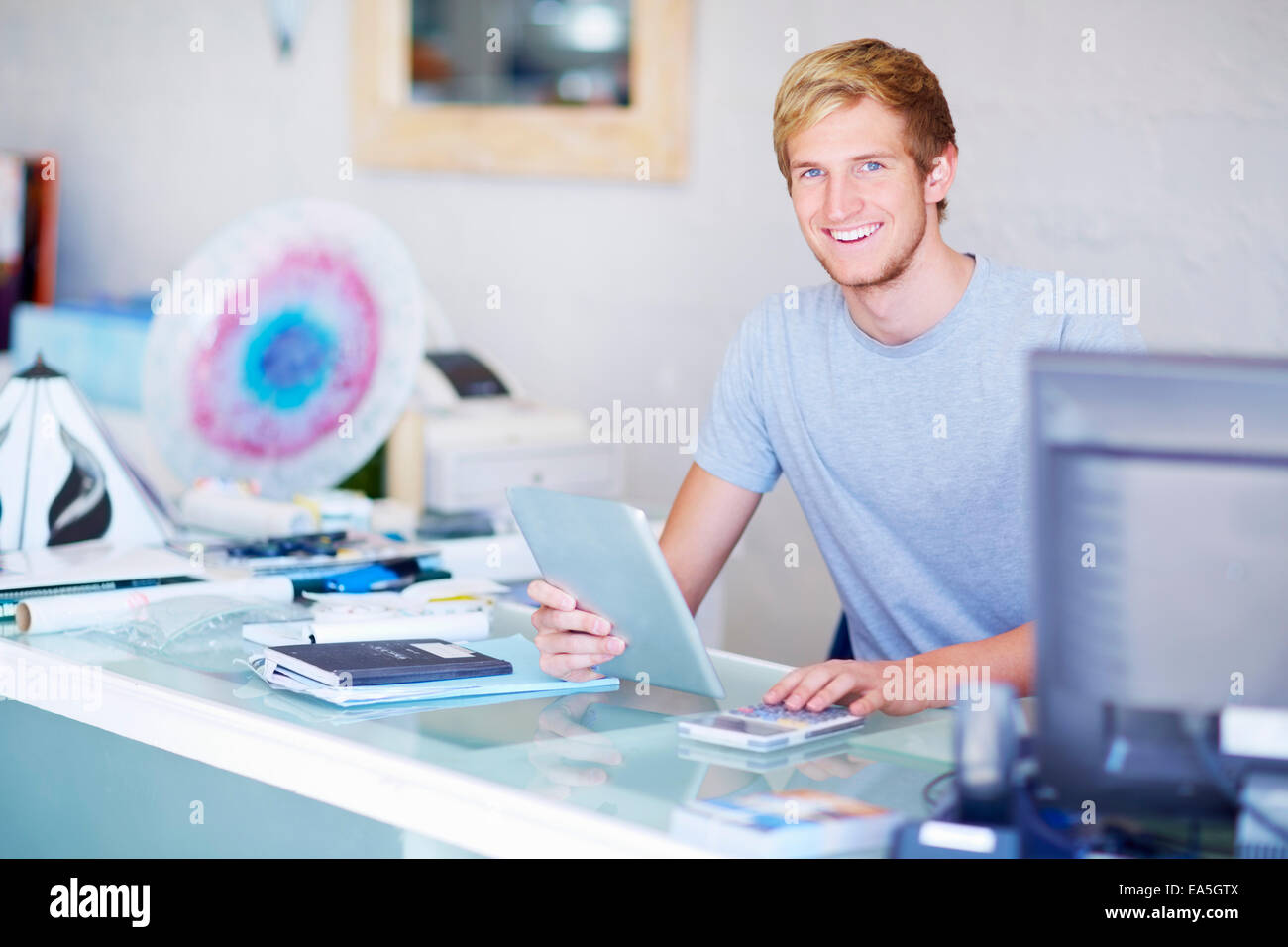 Smiling young man at shop counter Stock Photo - Alamy