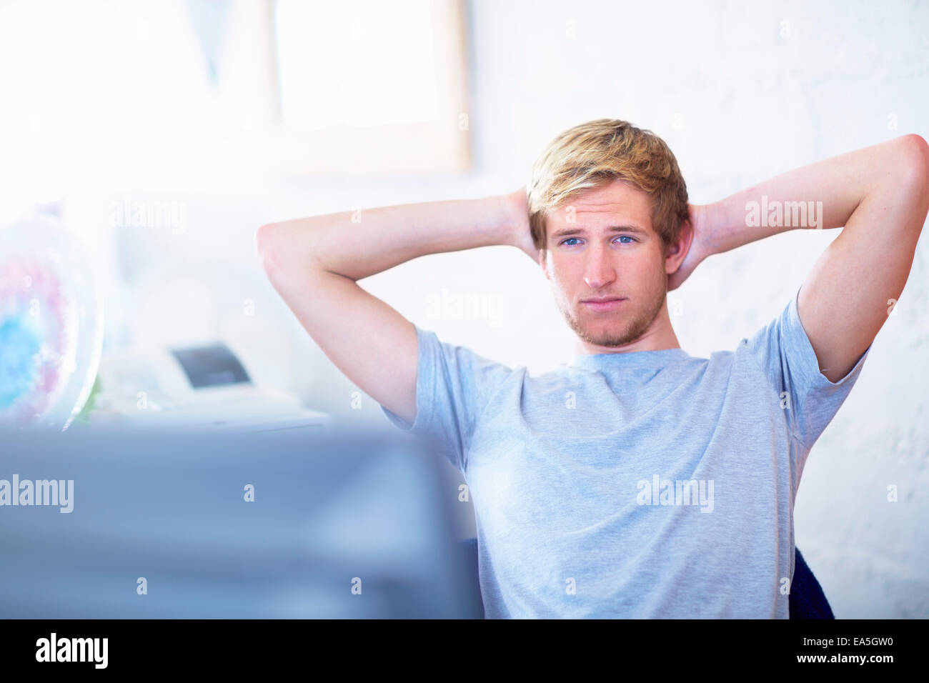 Young man looking at computer monitor Stock Photo - Alamy